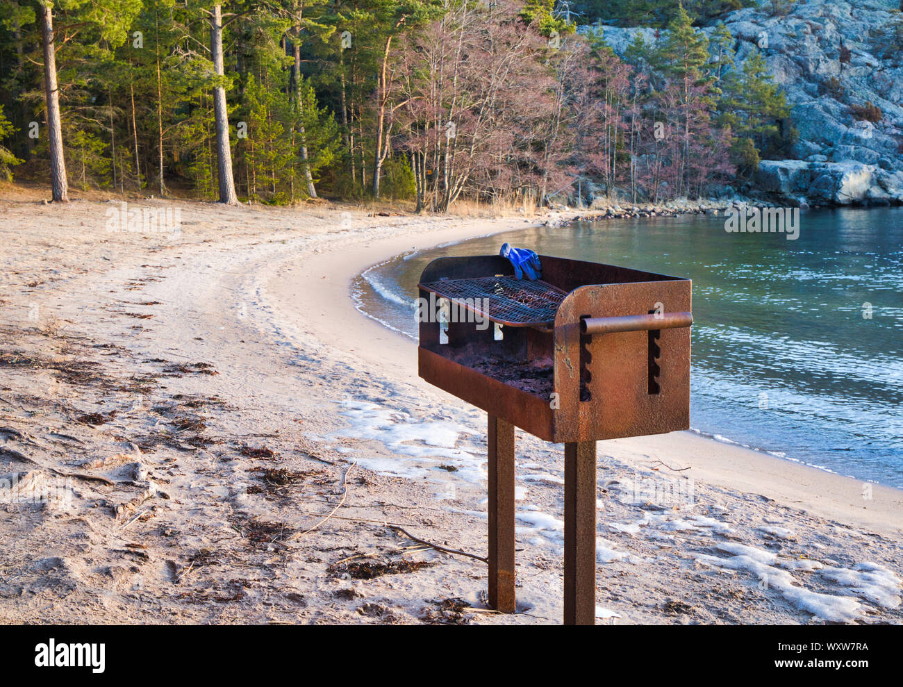 Rusty barbecue on beach with sand and snow, Stavsnas, Stockholm County ...