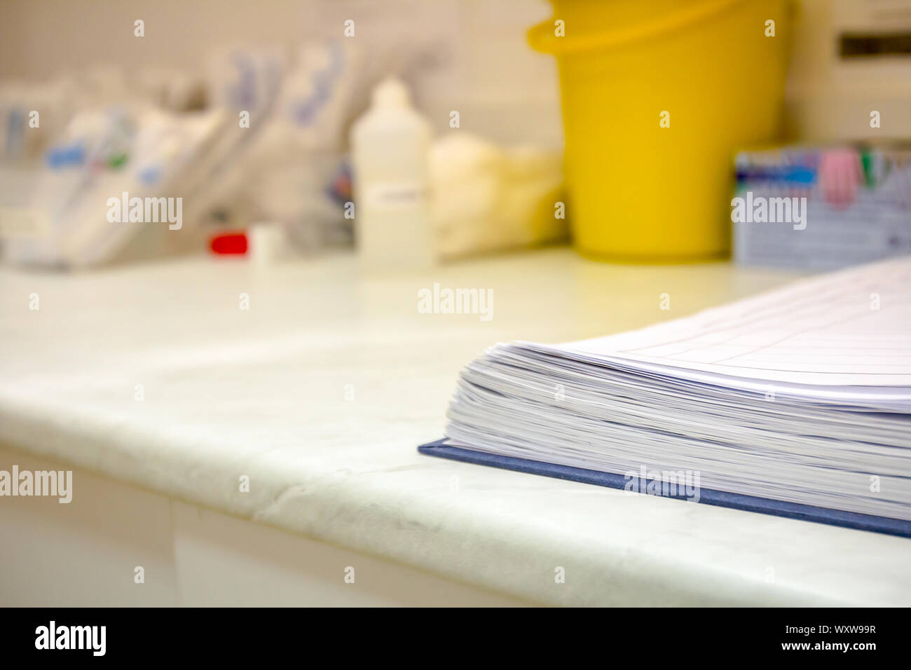 Doctor's table is covered with patient's book and various medical ...