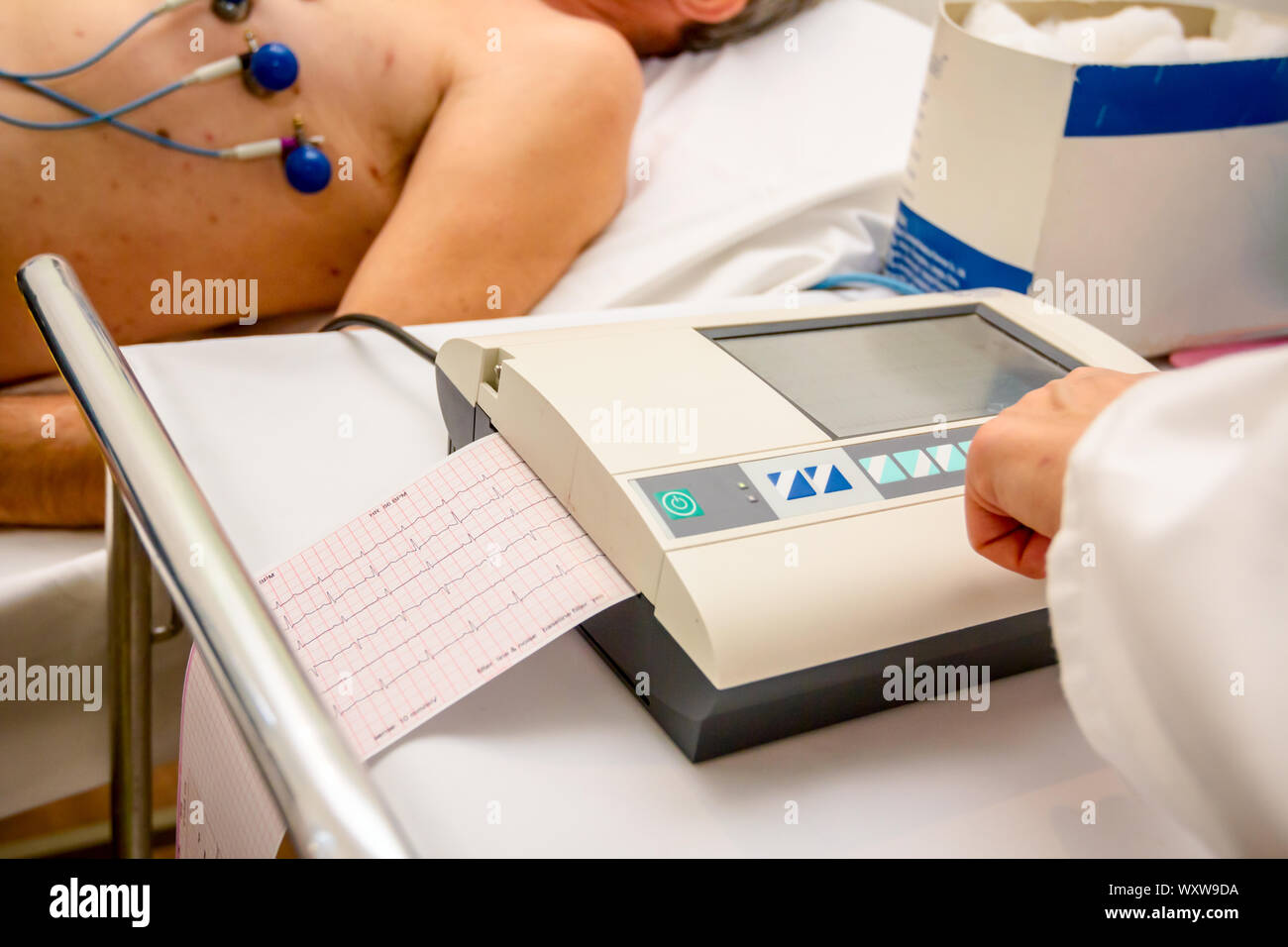 The cardiologist holding and review the electrocardiograph EKG or ECG ...