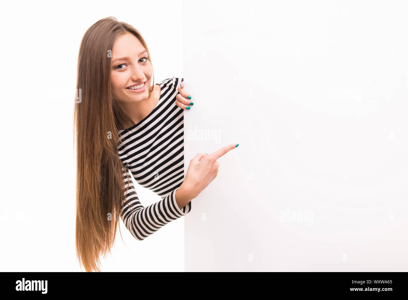 Young student point at white poster on white background Stock Photo - Alamy