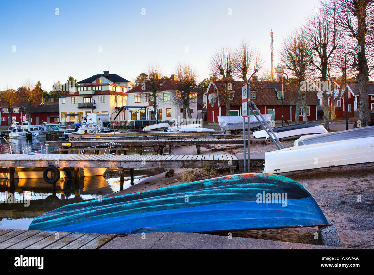 Blue upturned rowing boat and rustic wooden piers at dusk, Sandhamn ...