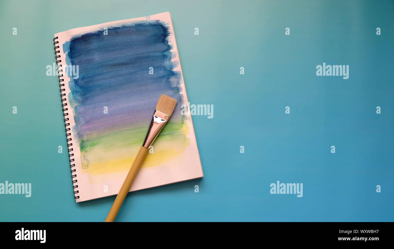 A drawing pad with watercolor gradient from blue to yellow, and a large ...