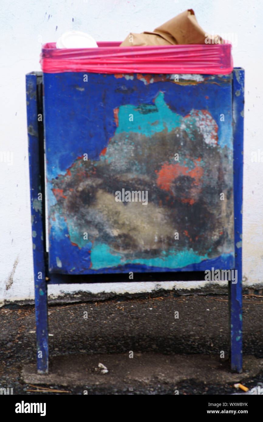 A brightly painted waste container with peeling paint Stock Photo - Alamy