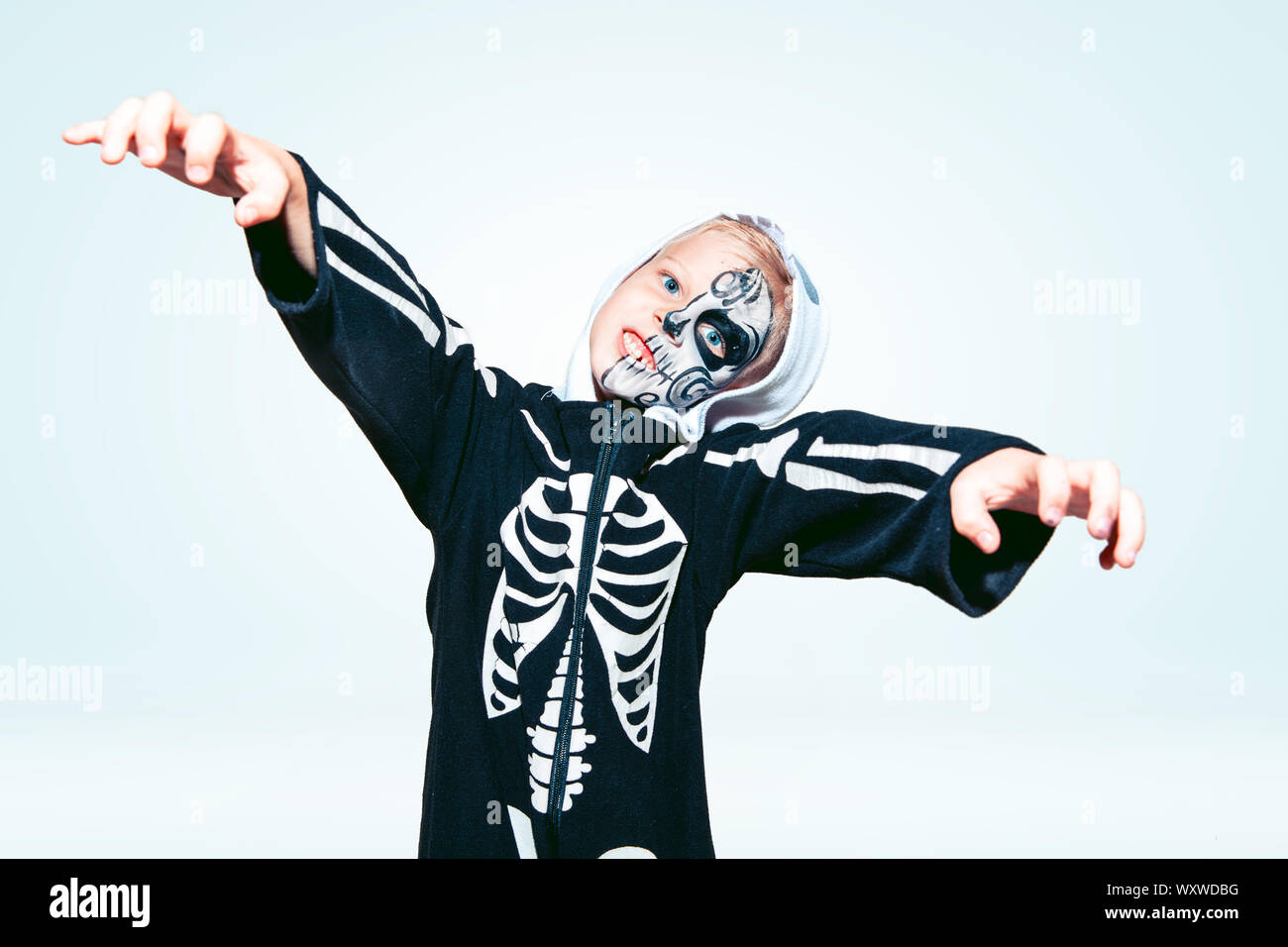 Little boy like a vampire in scary black costume with bones on white ...