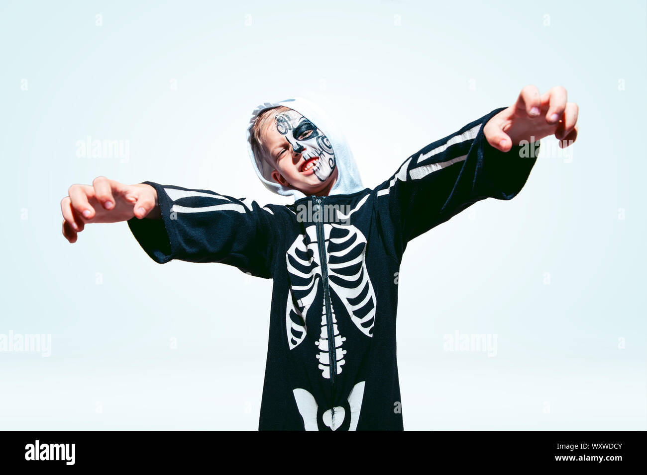 Little boy like a vampire in scary black costume with bones on white ...
