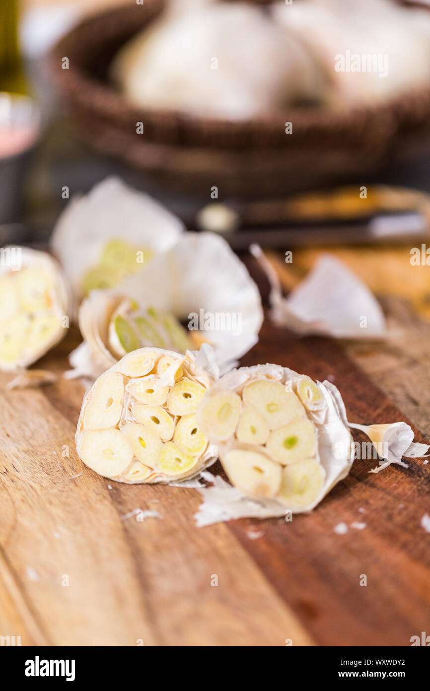 Cutting garlic heads to preapre roasted garlic spread Stock Photo - Alamy