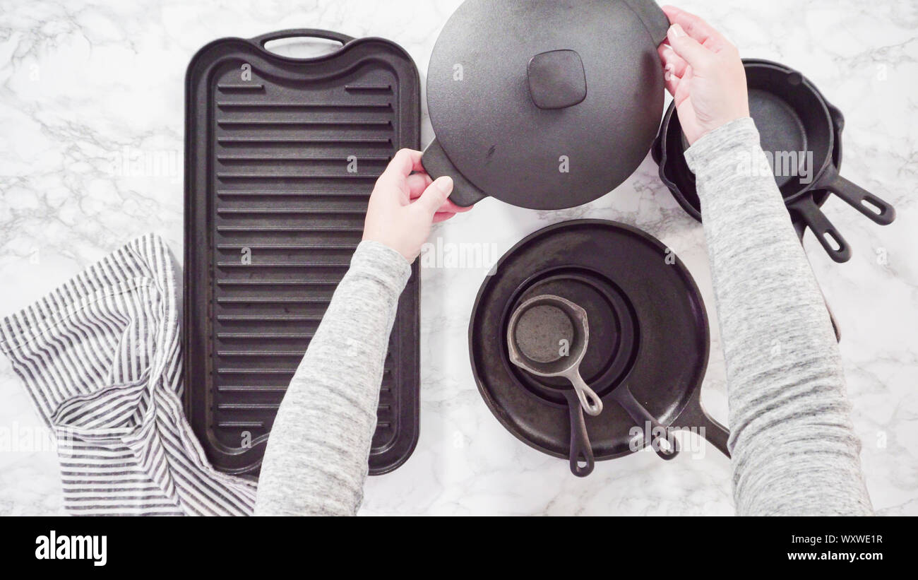 Flat lay. Variety of cast iron kitchenware on a marble countertop Stock ...
