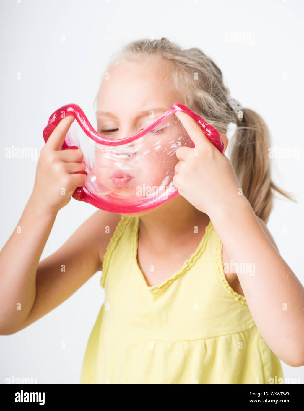 Happy joyful girl playing a red slime Stock Photo - Alamy