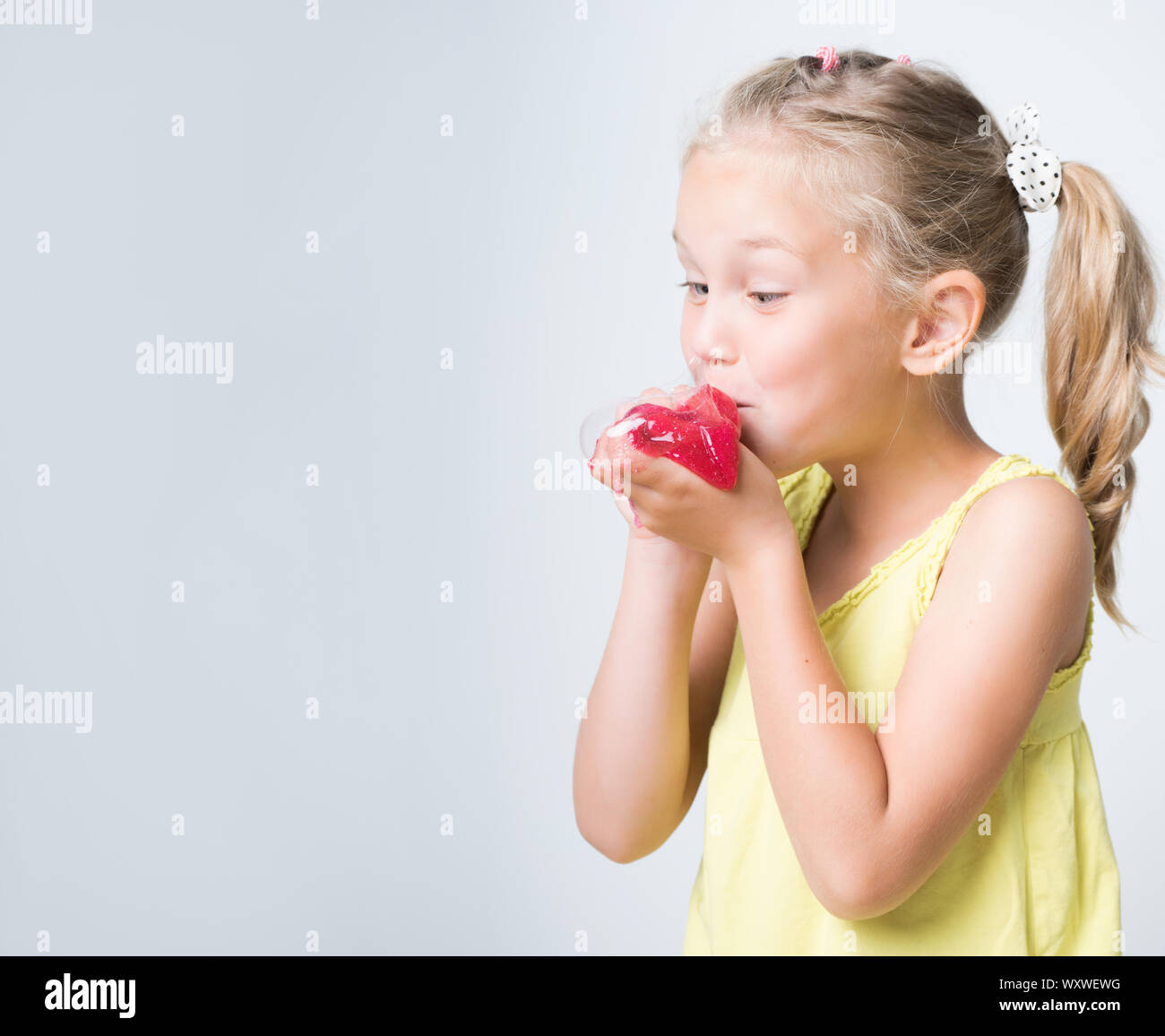 Happy joyful girl playing a red slime Stock Photo - Alamy