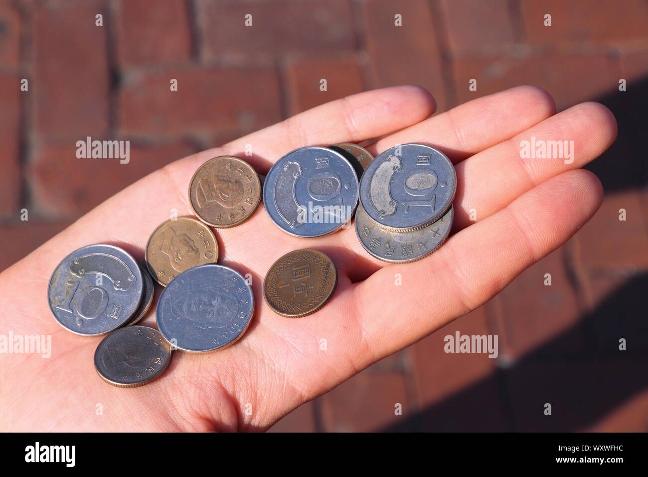 New Taiwan dollars currency - hand holding NTD coins Stock Photo - Alamy