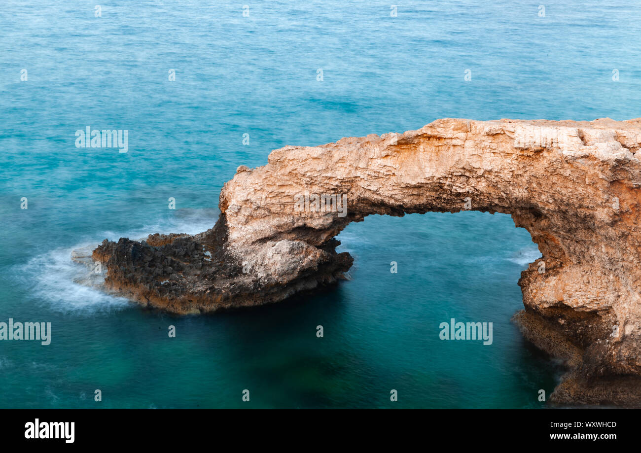 Stone arch known as the Love bridge. Mediterranean Sea coast. Natural ...