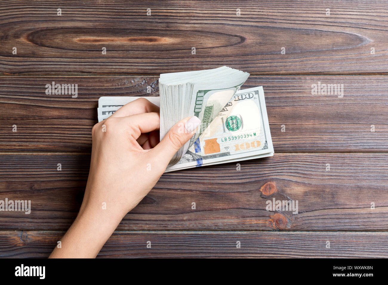 Top view of female hands counting money. One hundred dollar banknotes ...