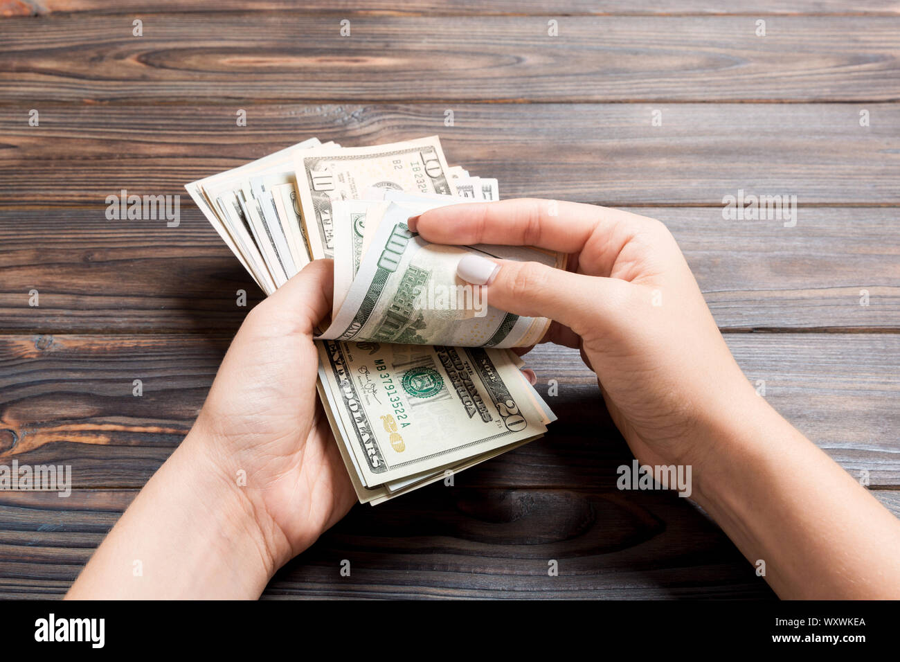 Perspective view of female hands counting money. One hundred dollar ...