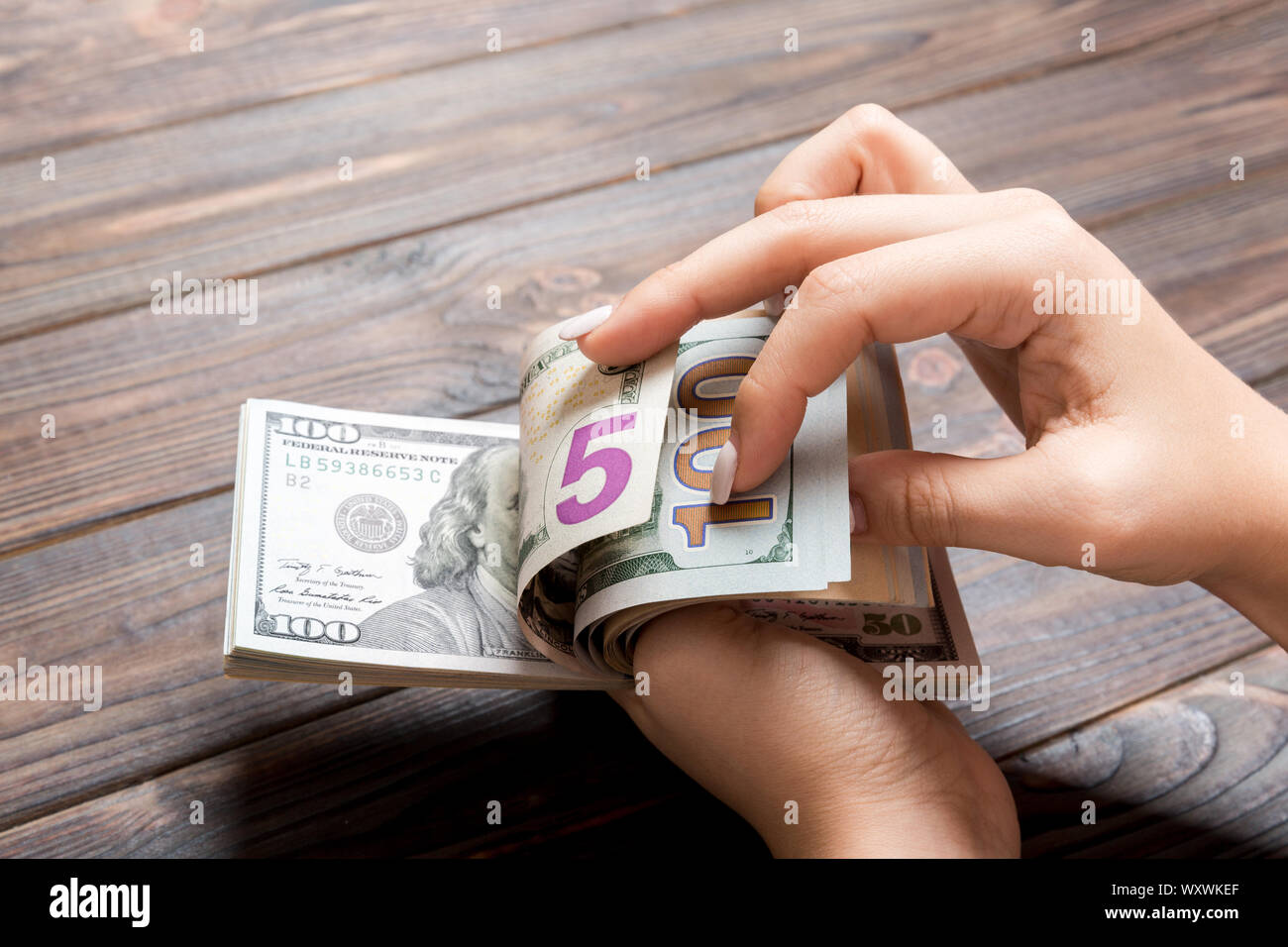 Perspective view of female hands counting money. One hundred and other ...