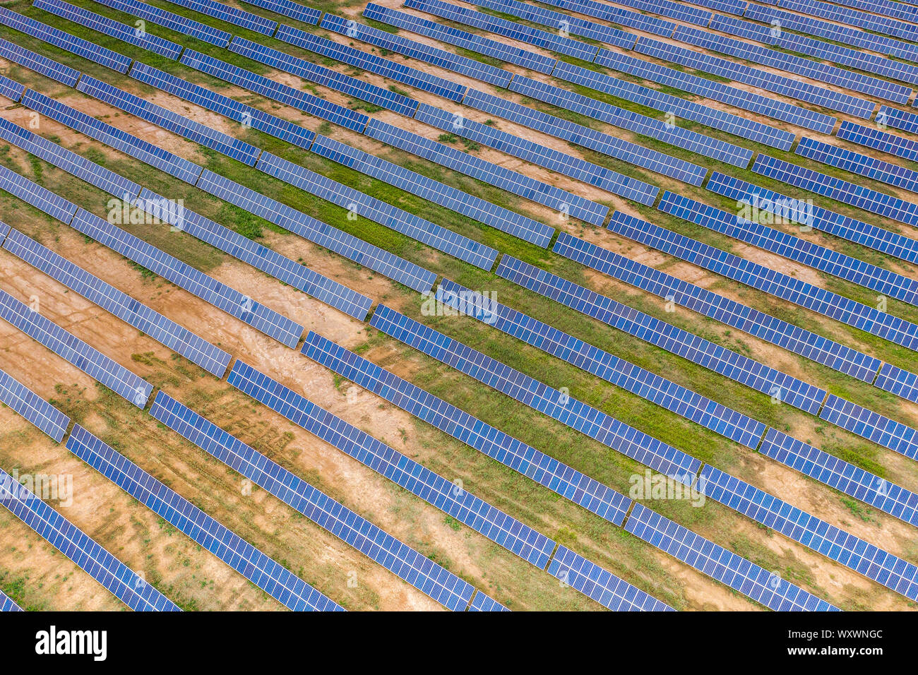 An aerial view of arrays of solar panels at a photovoltaic power plant ...