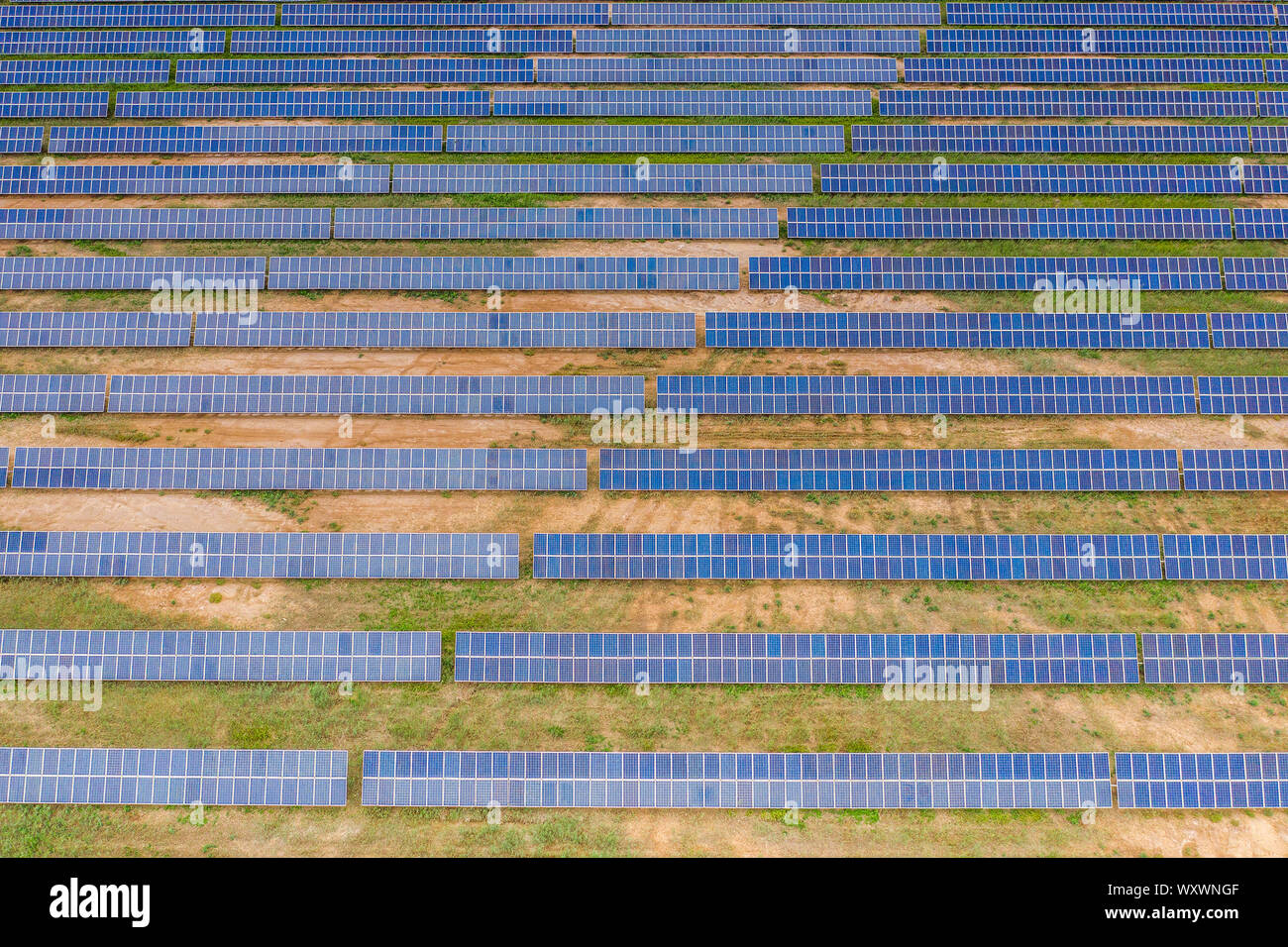 An aerial view of arrays of solar panels at a photovoltaic power plant ...