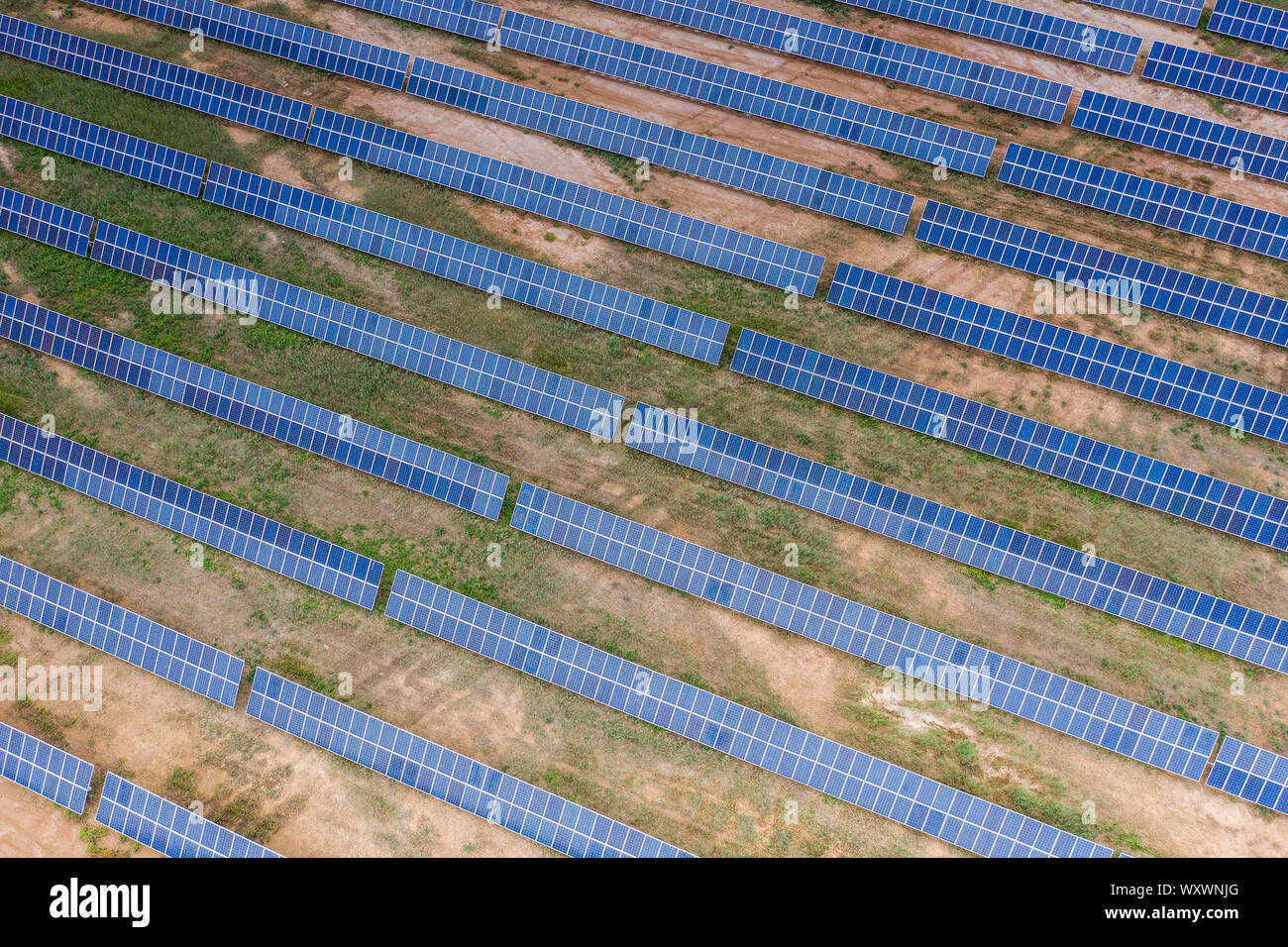 An aerial view of arrays of solar panels at a photovoltaic power plant ...