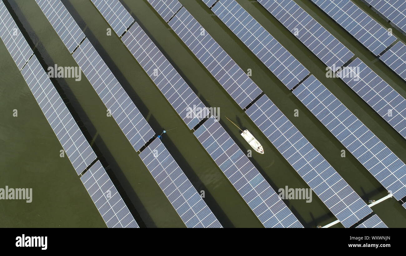 An aerial view of arrays of solar panels at a photovoltaic power ...