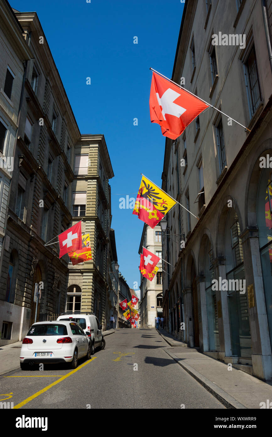 Street in the Old town of Geneva with swiss flags and flags of the ...