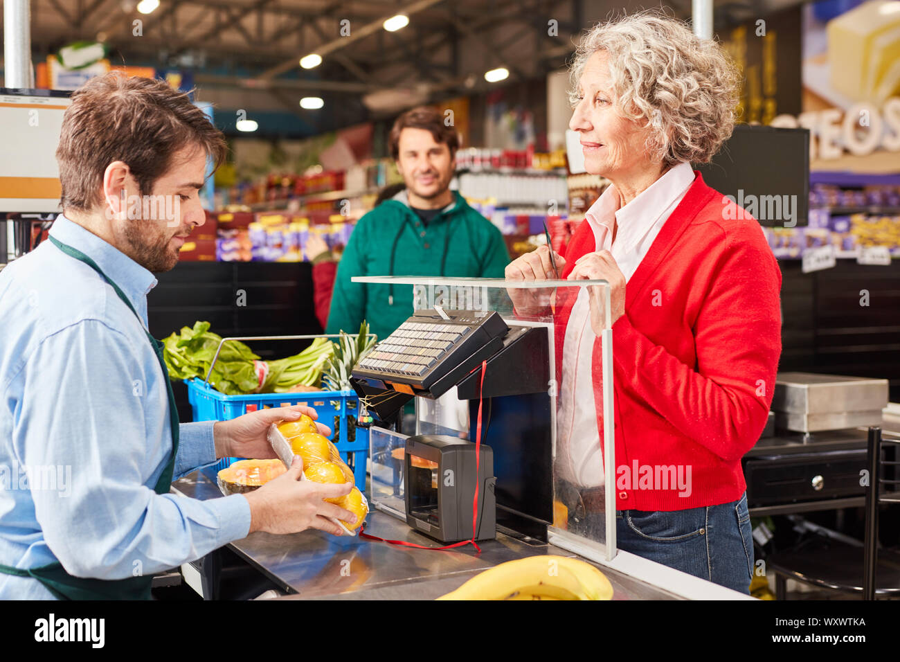 Customer at checkout in supermarket looks at cashier at work Stock ...