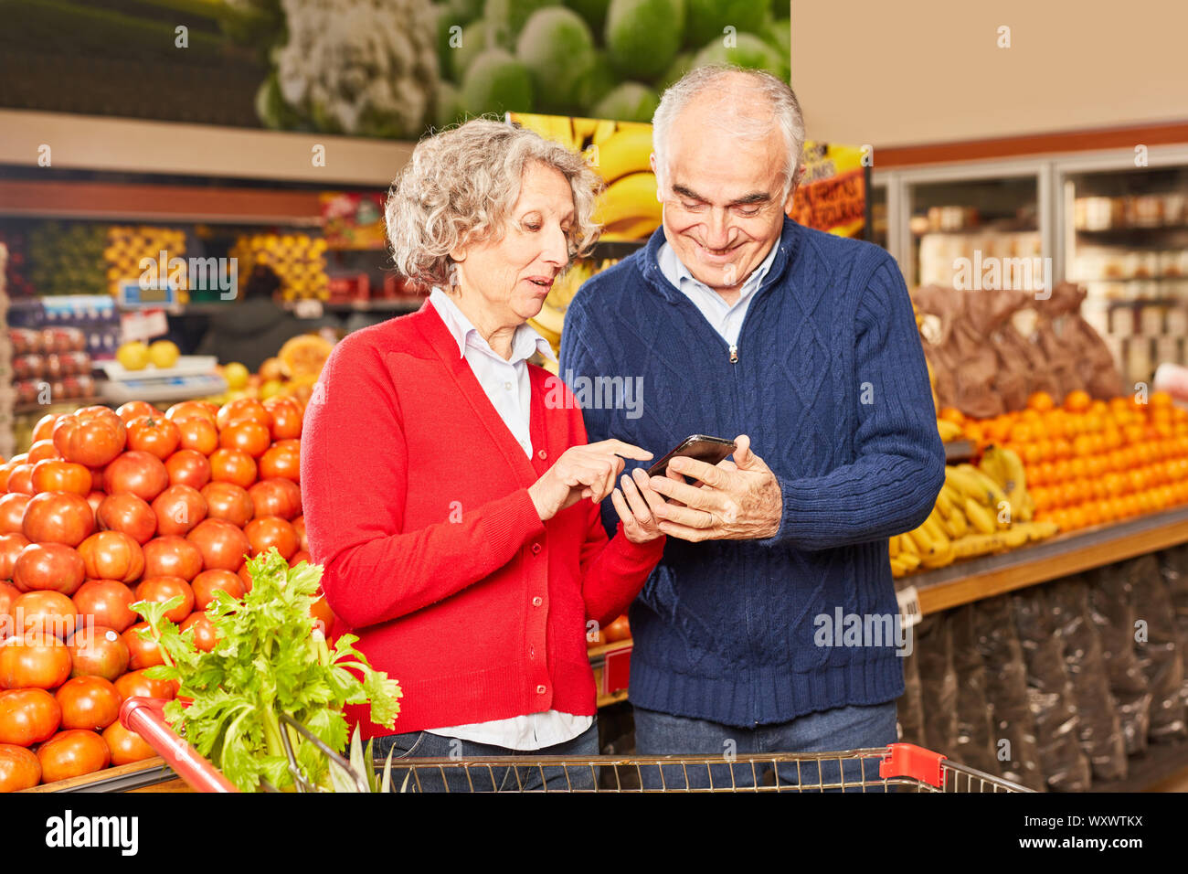 Couple of seniors as consumers uses smartphone app for price comparison ...