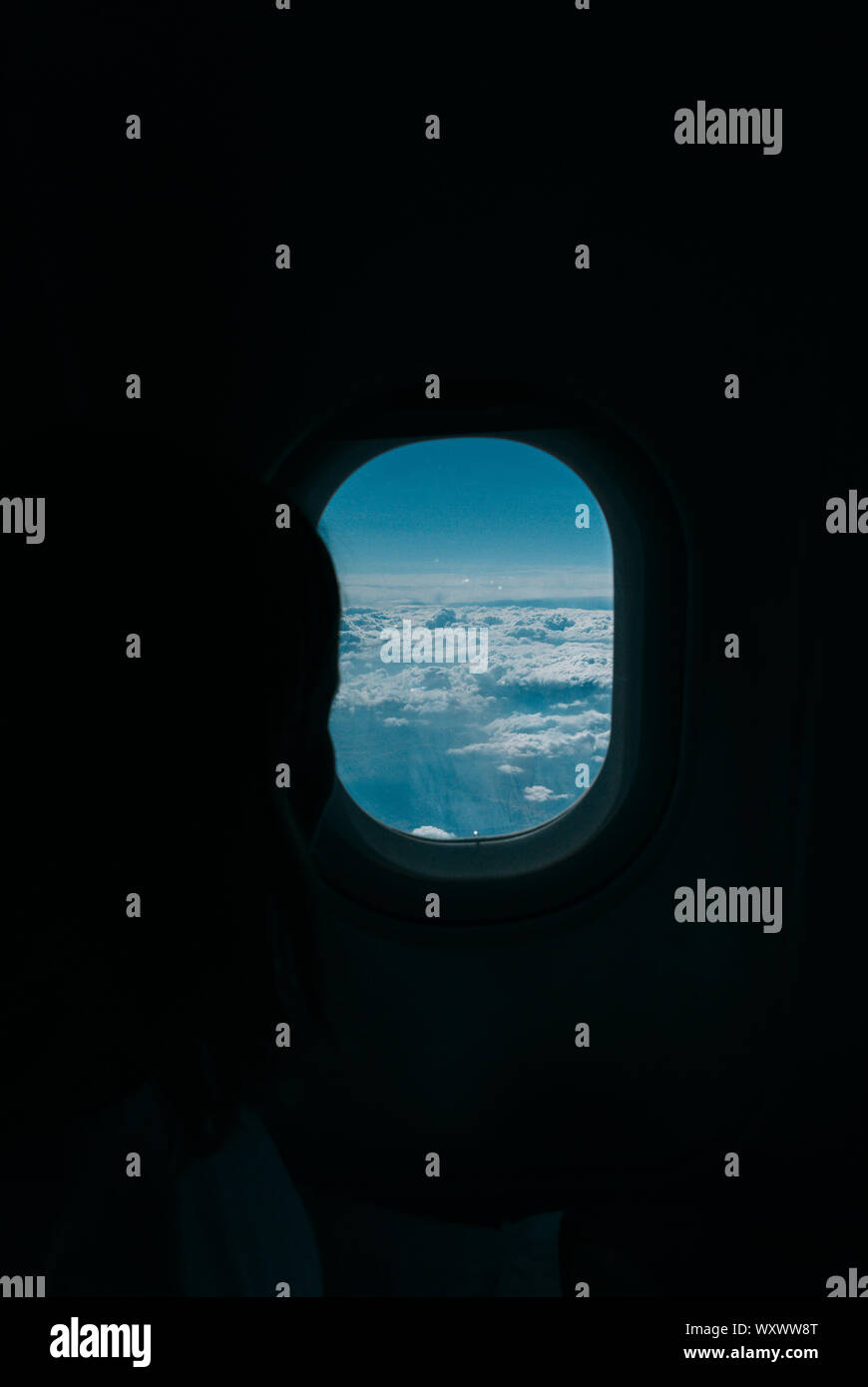 Woman looking through window of plane hi-res stock photography and ...