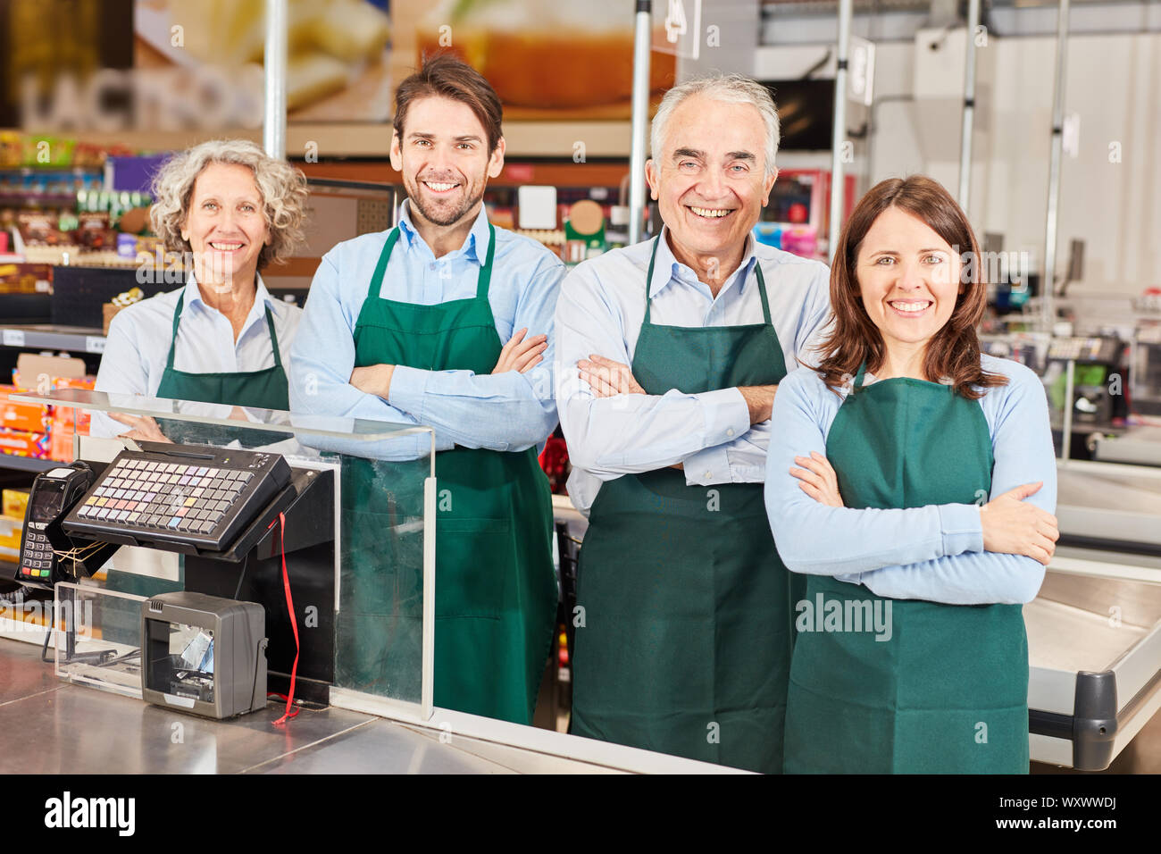 Happy group of sales people with market leader at the cash desk in the ...