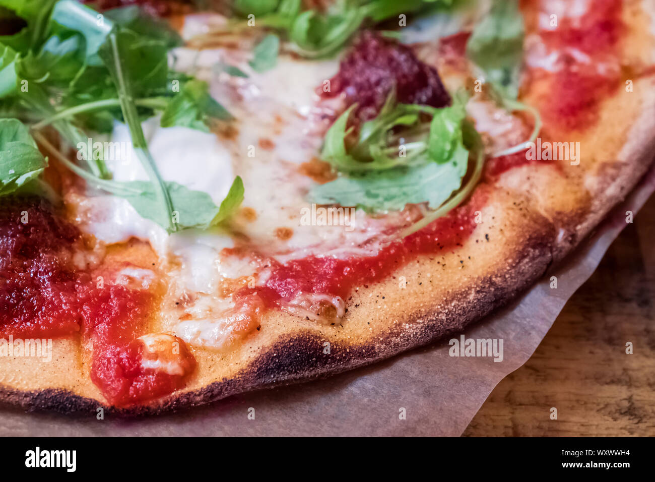 Delicious italian pizza with thin crust and fresh arugula Stock Photo ...