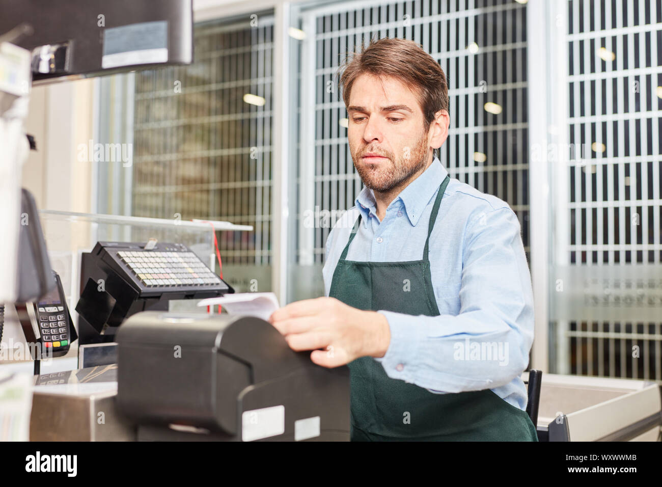 Cashier or market leader checking a retail cash register Stock Photo ...