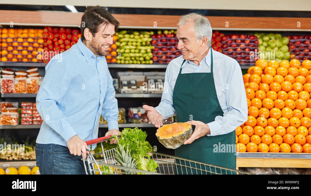 Customer gets advice in the supermarket from a seller in the fruit ...