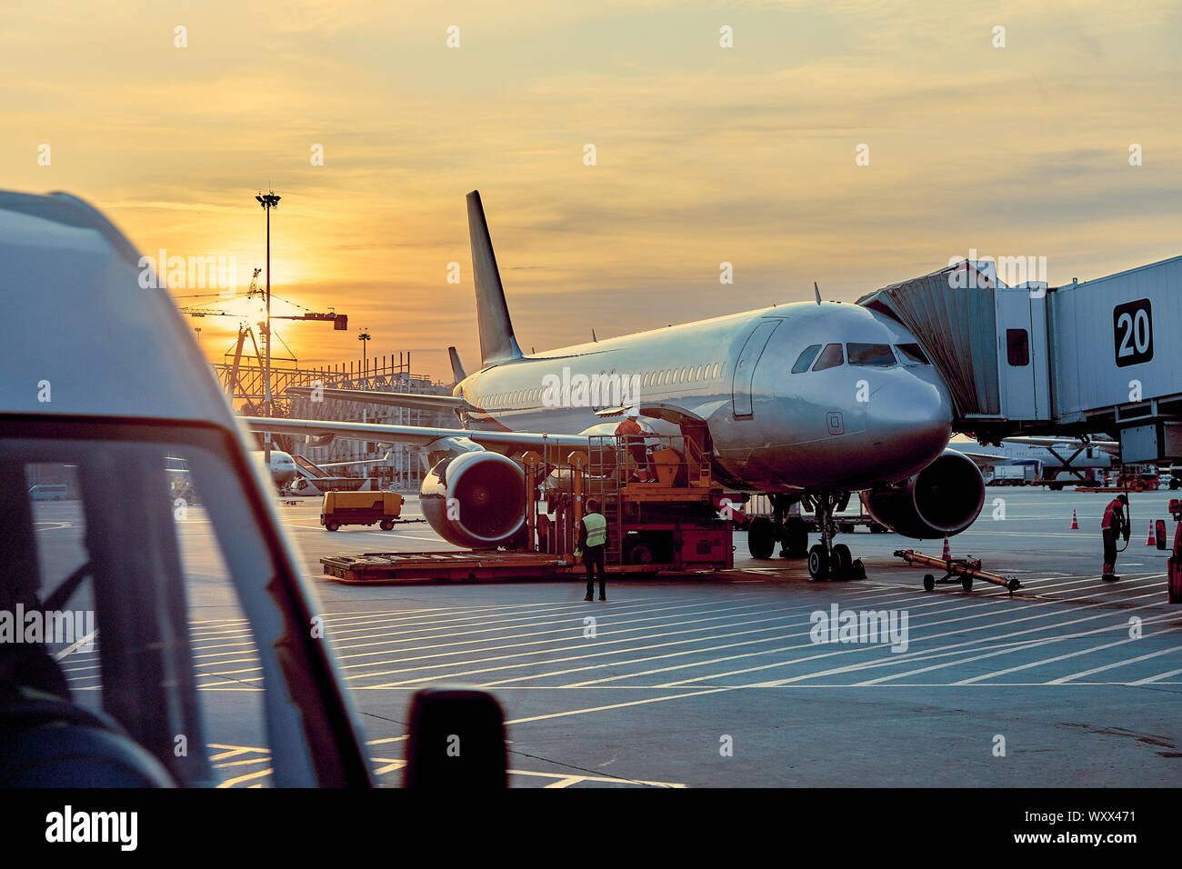 Modern passenger airplane parked to terminal building gate at airside ...