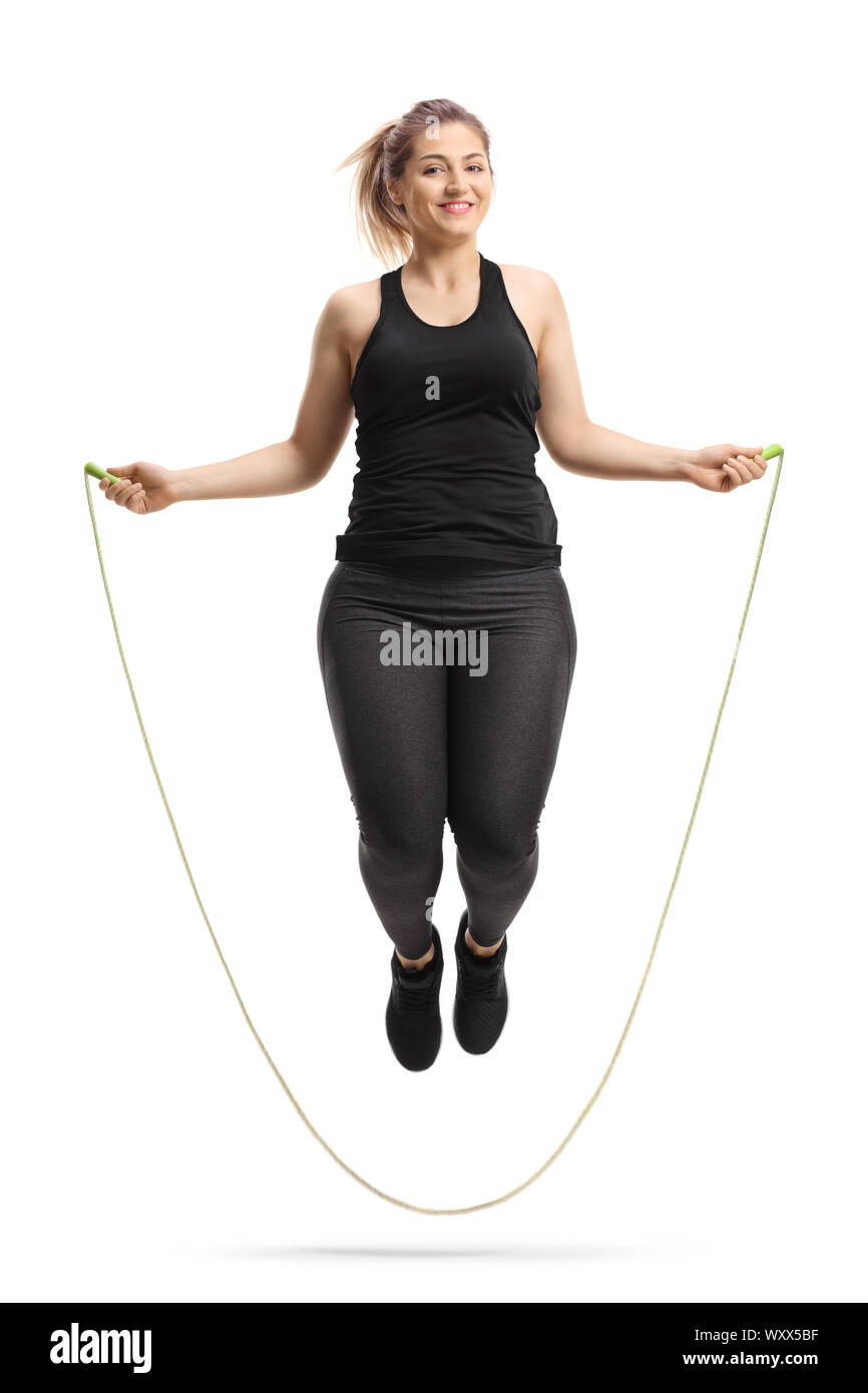 Full length portrait of a young cheerful woman skipping a rope isolated ...