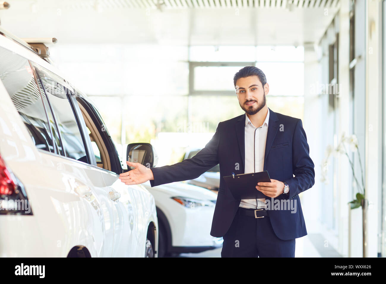 A car dealer shows a auto in a showroom. Auto business Stock Photo - Alamy