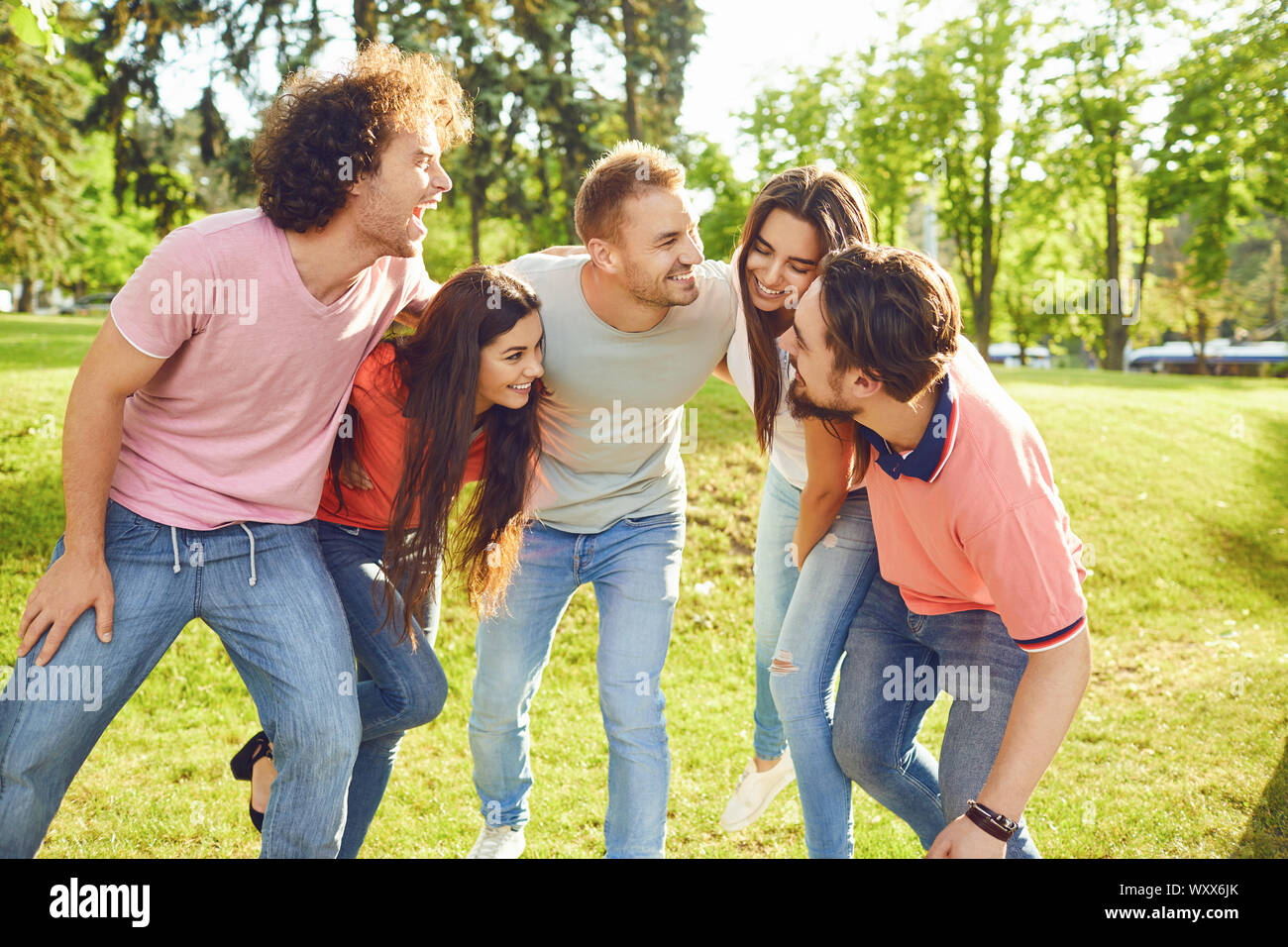 A group of friends laughing hugging in a park Stock Photo - Alamy