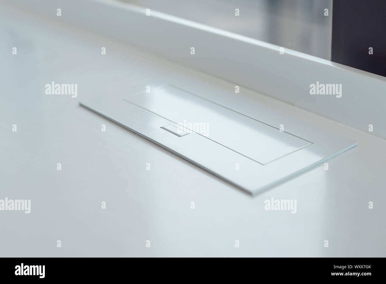 Pop up internal socket in a white table, charging for phones and ...