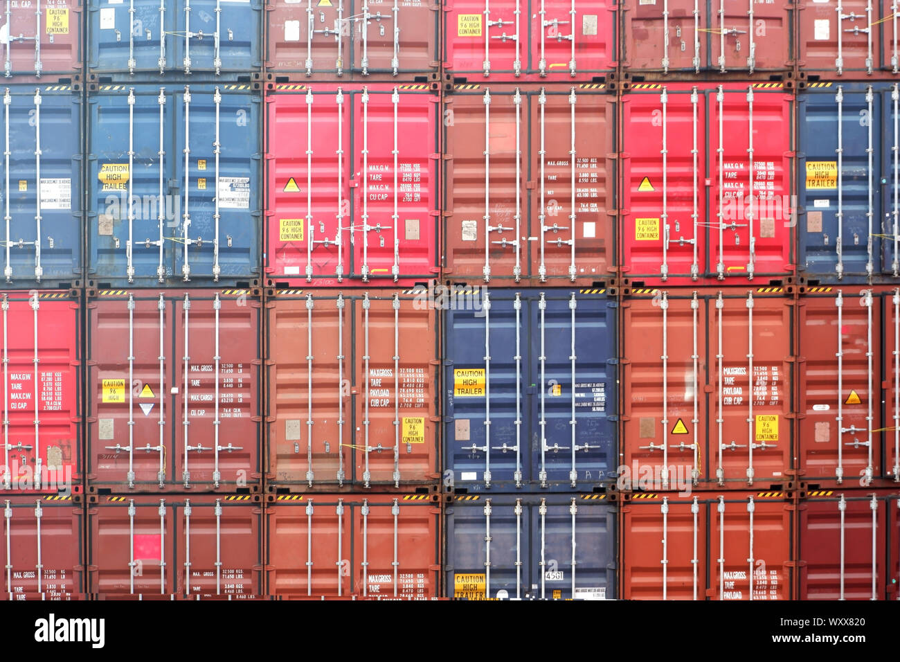 A view of many shipping containers doors while stacked on warehouse ...