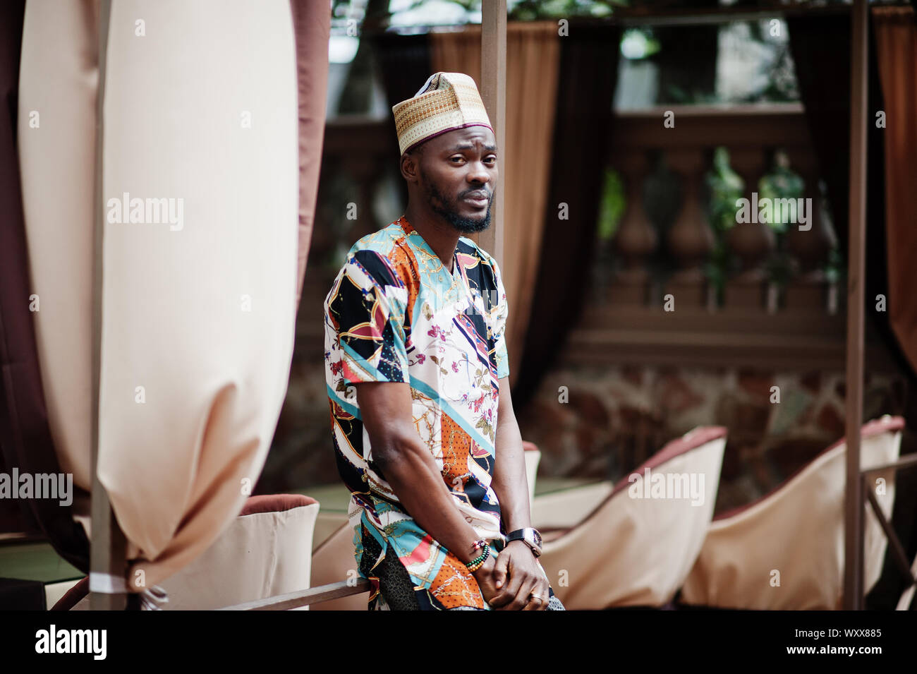 Handsome afro american man wearing traditional clothes and cap in ...