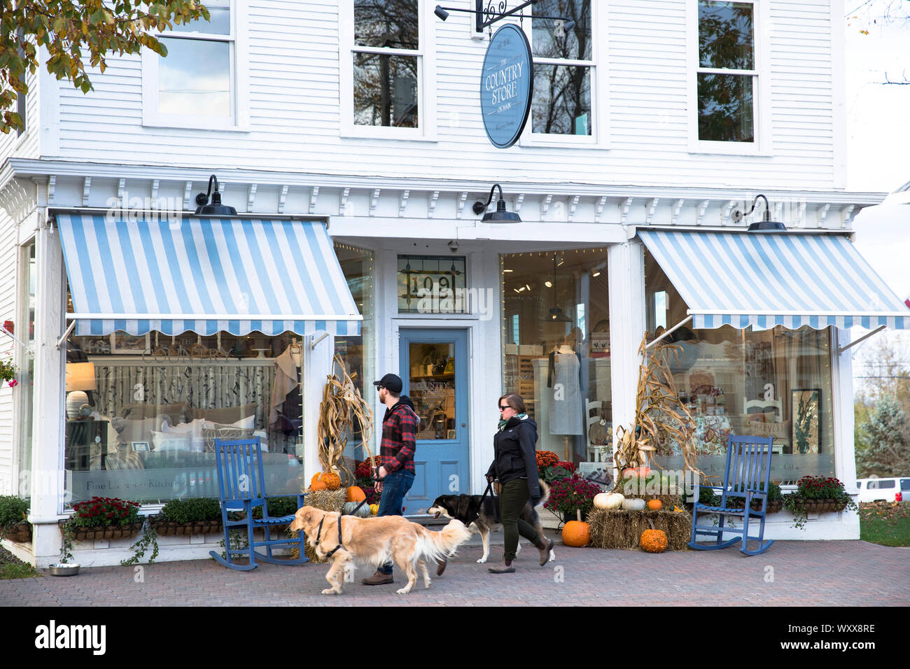 Local people walking dogs past The Country Store on Main Street in ...