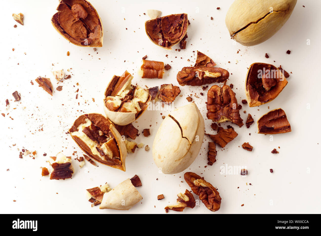 Cracked and opened pecan nuts and nuts in shell. Overhead wiew on white ...