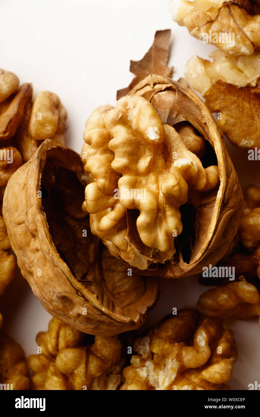 Close up top view of a heap of raw walnuts with a nutshell on white ...