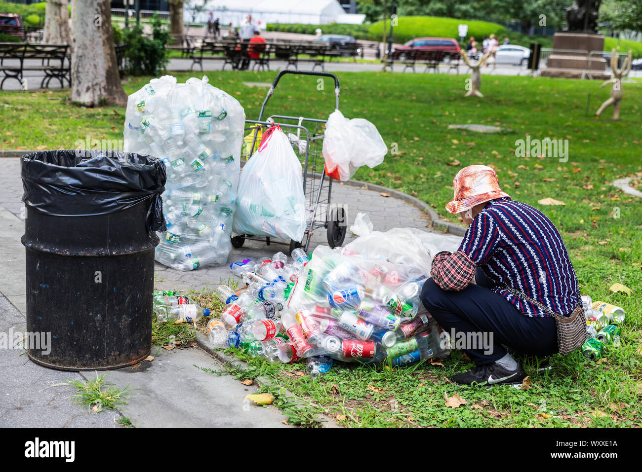 New York City, USA - August 2, 2018: Poor woman picking up plastic ...