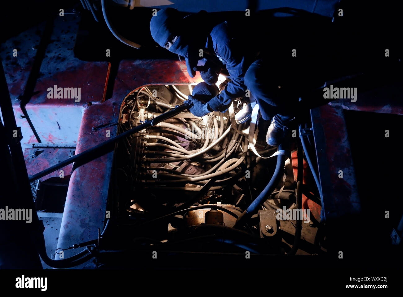 The mechanic is repairing the engine. at night Stock Photo - Alamy
