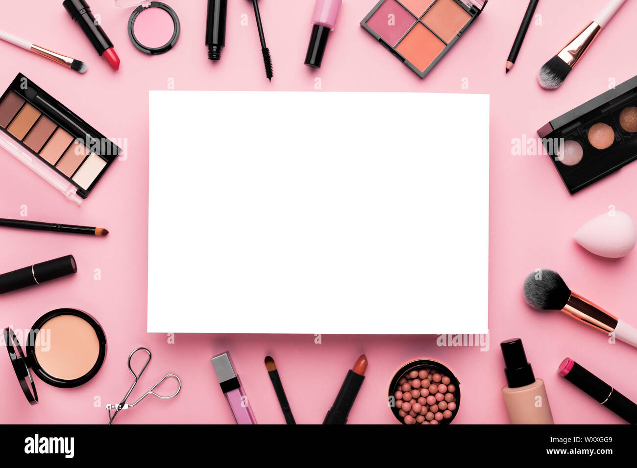 White blank sheet of paper surrounded by luxury decorative cosmetics ...