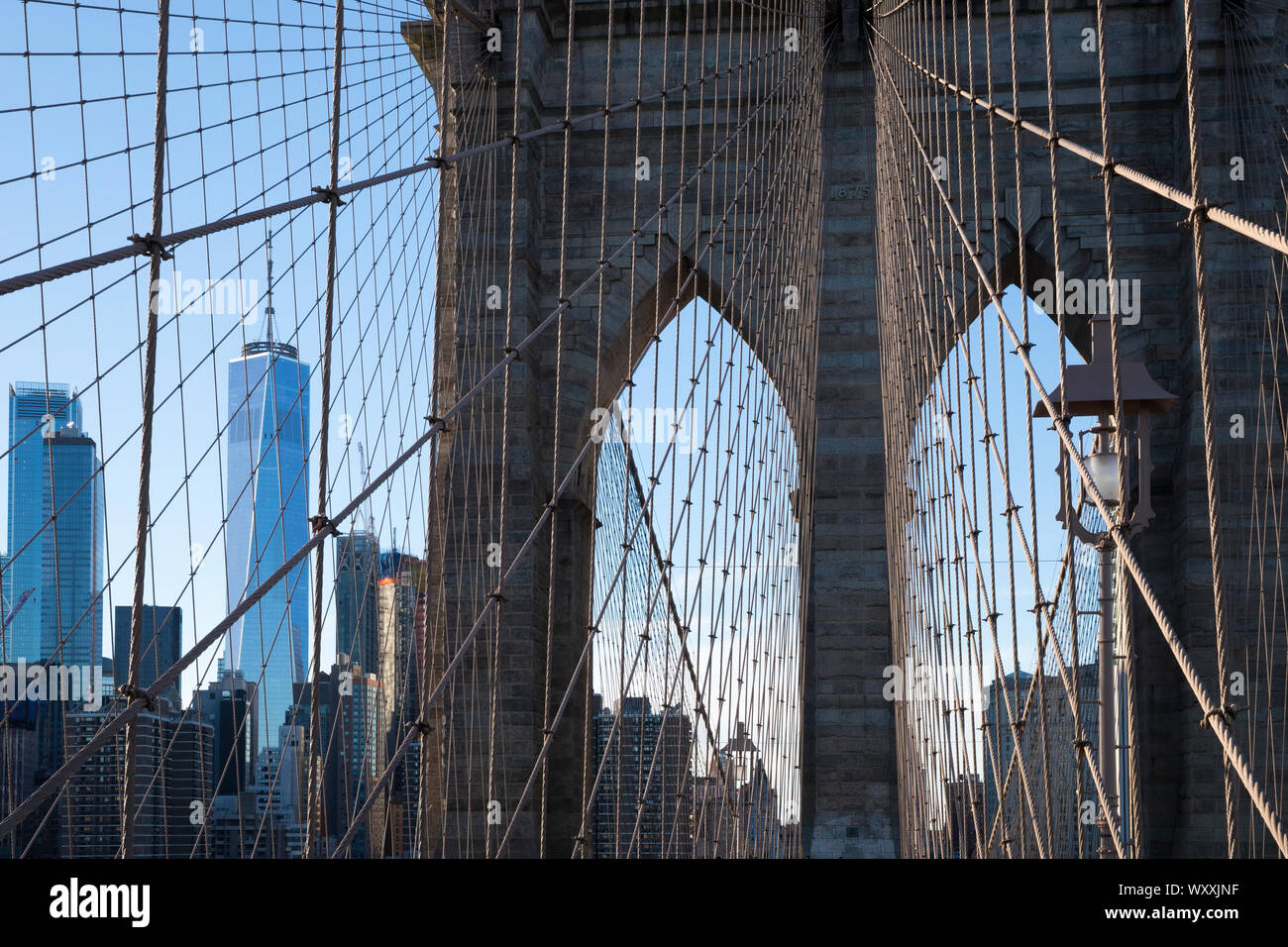 Skyscrapers of Manhattan viewed through piers, wire supports and cables ...