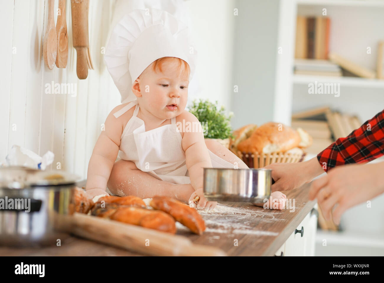 little baker child in chef hat at kitchen table alone with bread and buns Stock Photo - Alamy