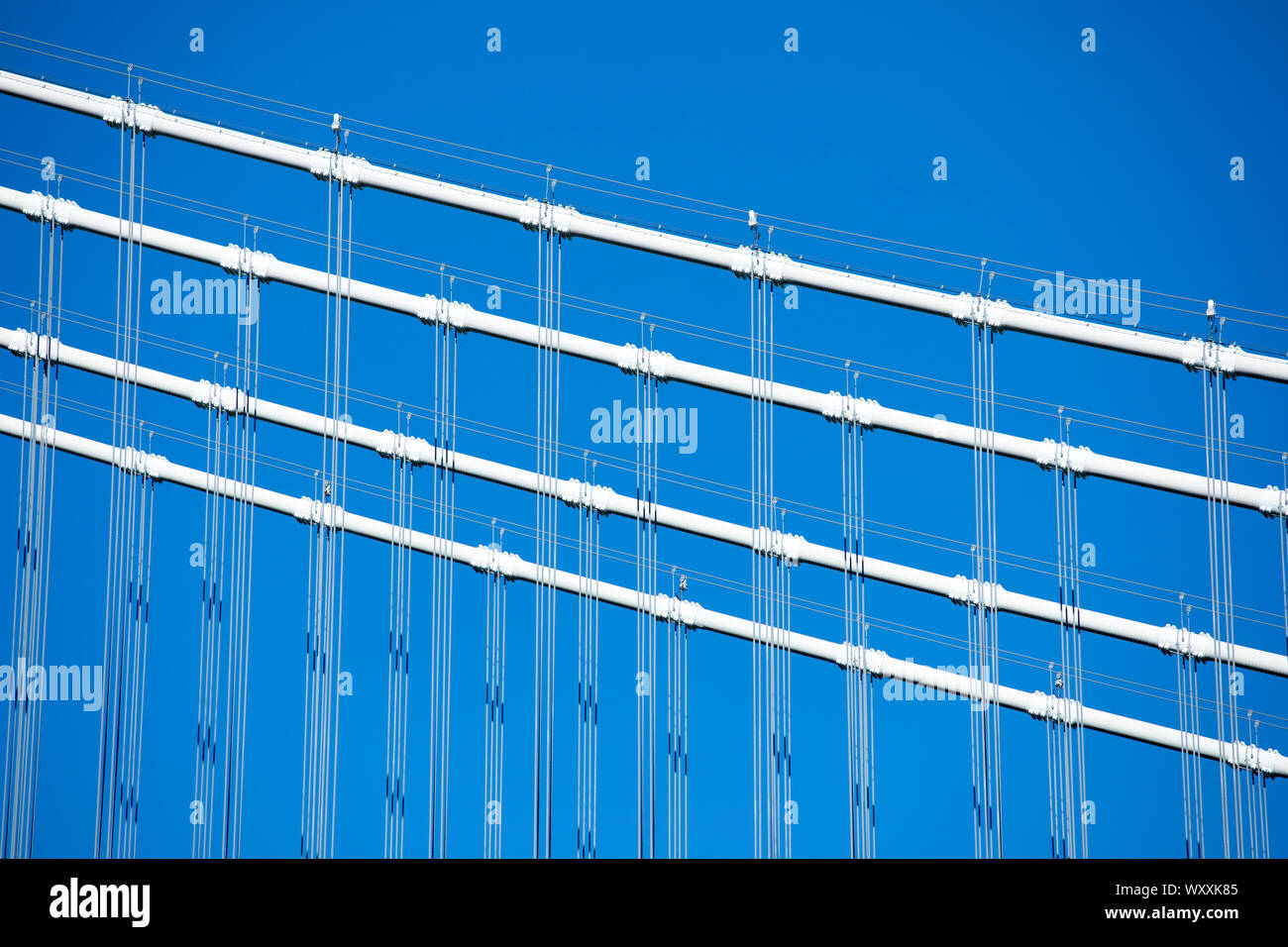 Wire supports and cables of Manhattan Bridge viewed against blue sky ...