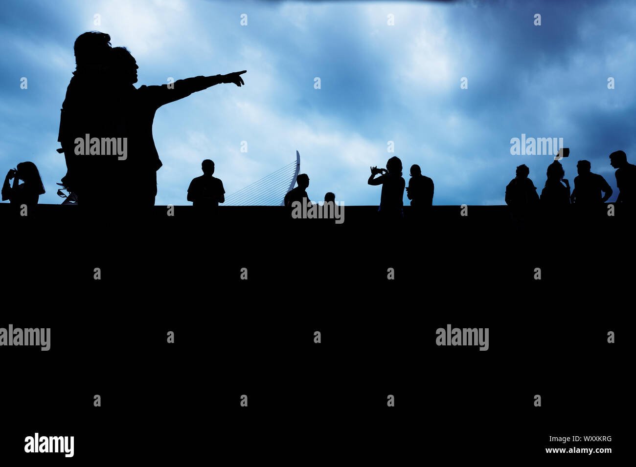 Silhouette of unrecognizable people pointing with a dark background ...