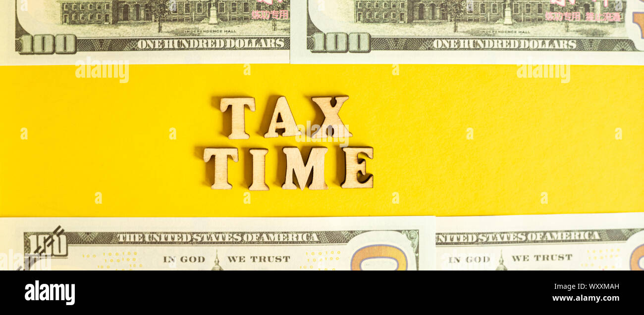 Economic phrase Tax Time isolated on yellow paper background with ...
