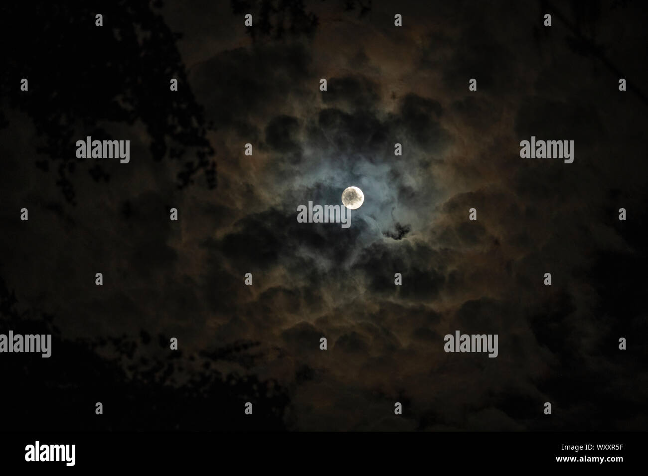 Full moon in cloudy night sky Stock Photo - Alamy