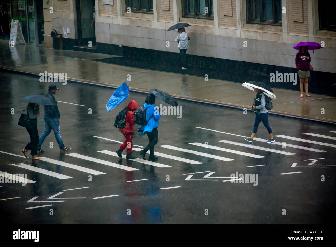 Pedestrians trudge through the rain in the Chelsea neighborhood of New ...